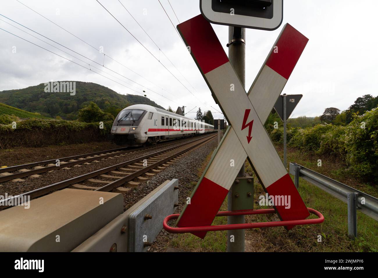 a red warning sign with a passenger train in background Stock Photo - Alamy