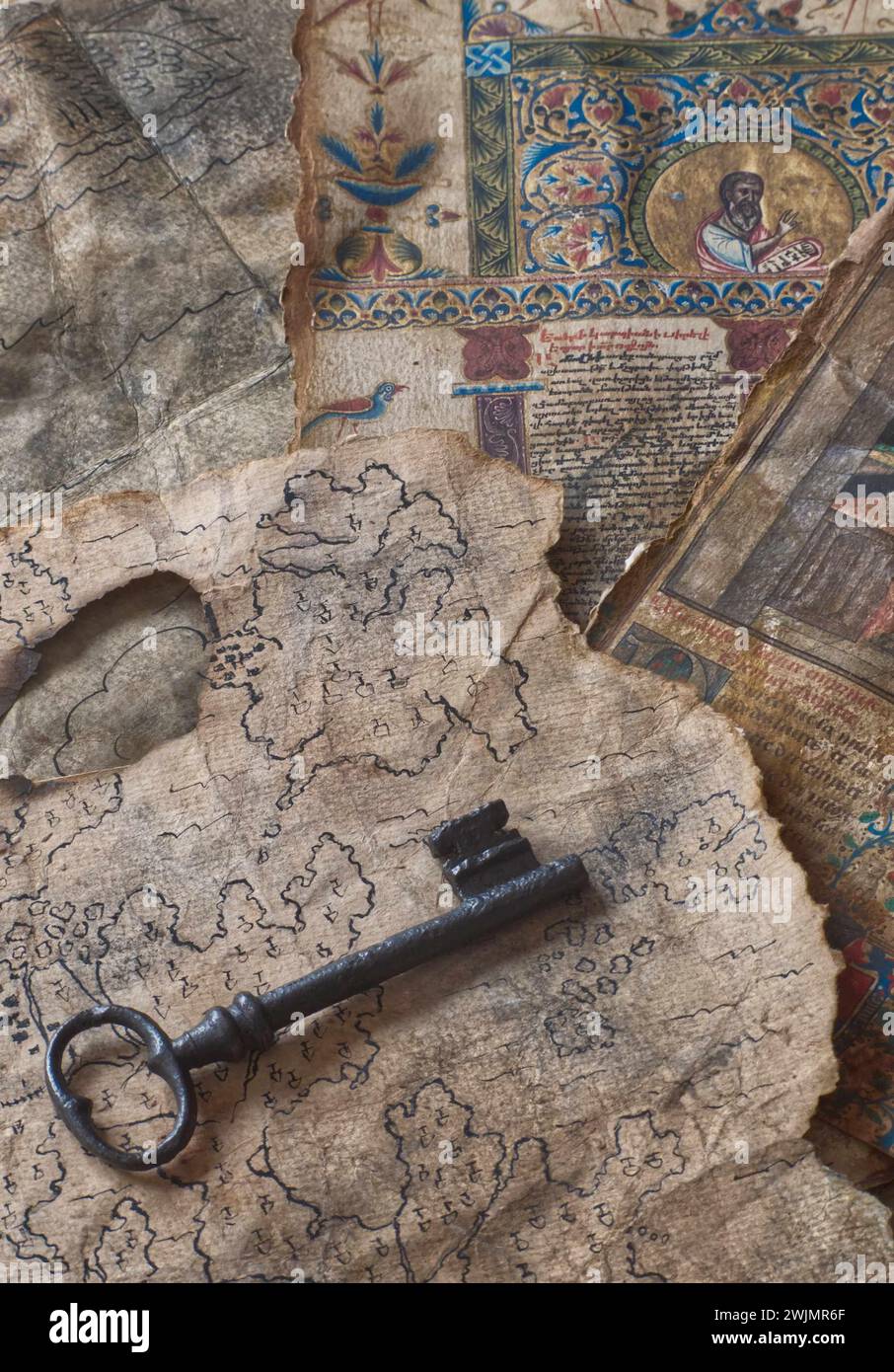 An old style key laying on old hand drawn maps and old manuscripts ...