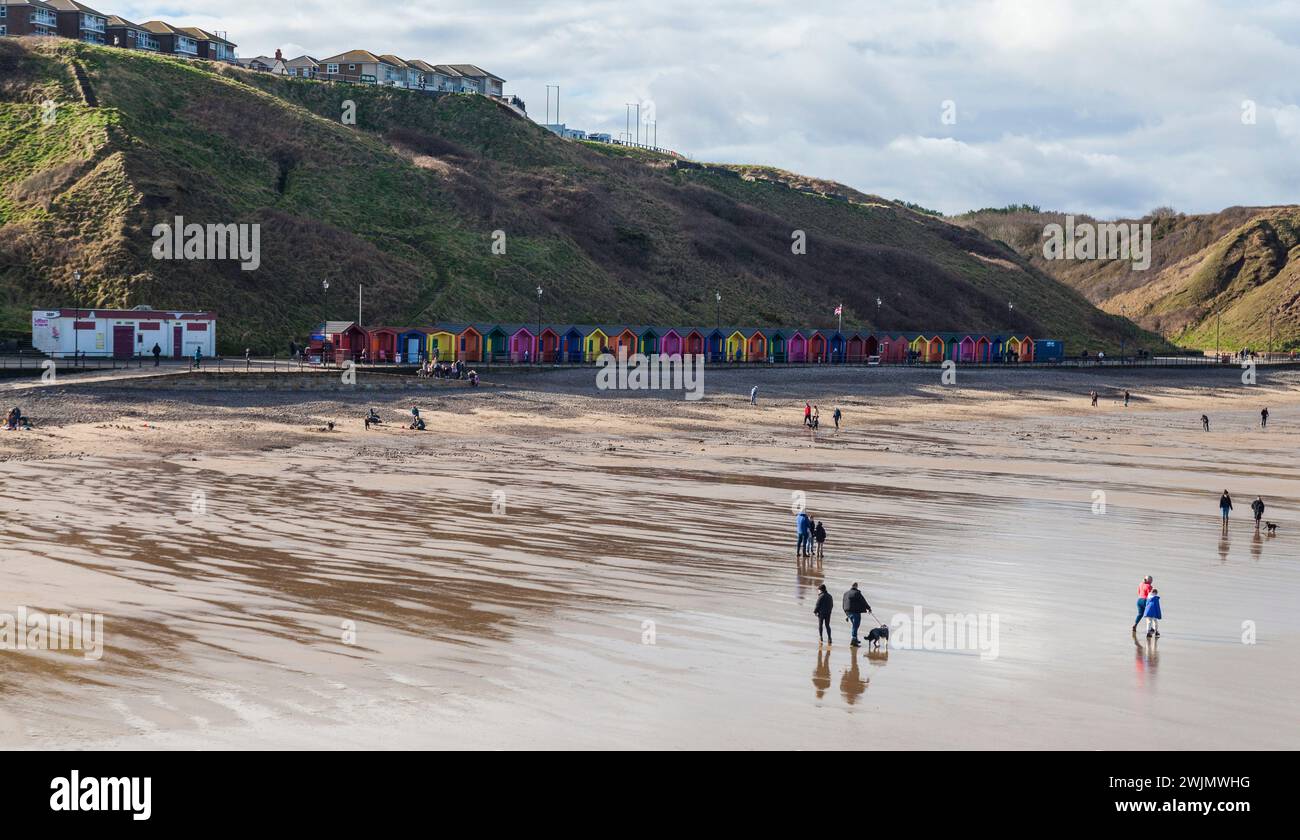 A view along the beach and the promenade with colourful beach huts at ...