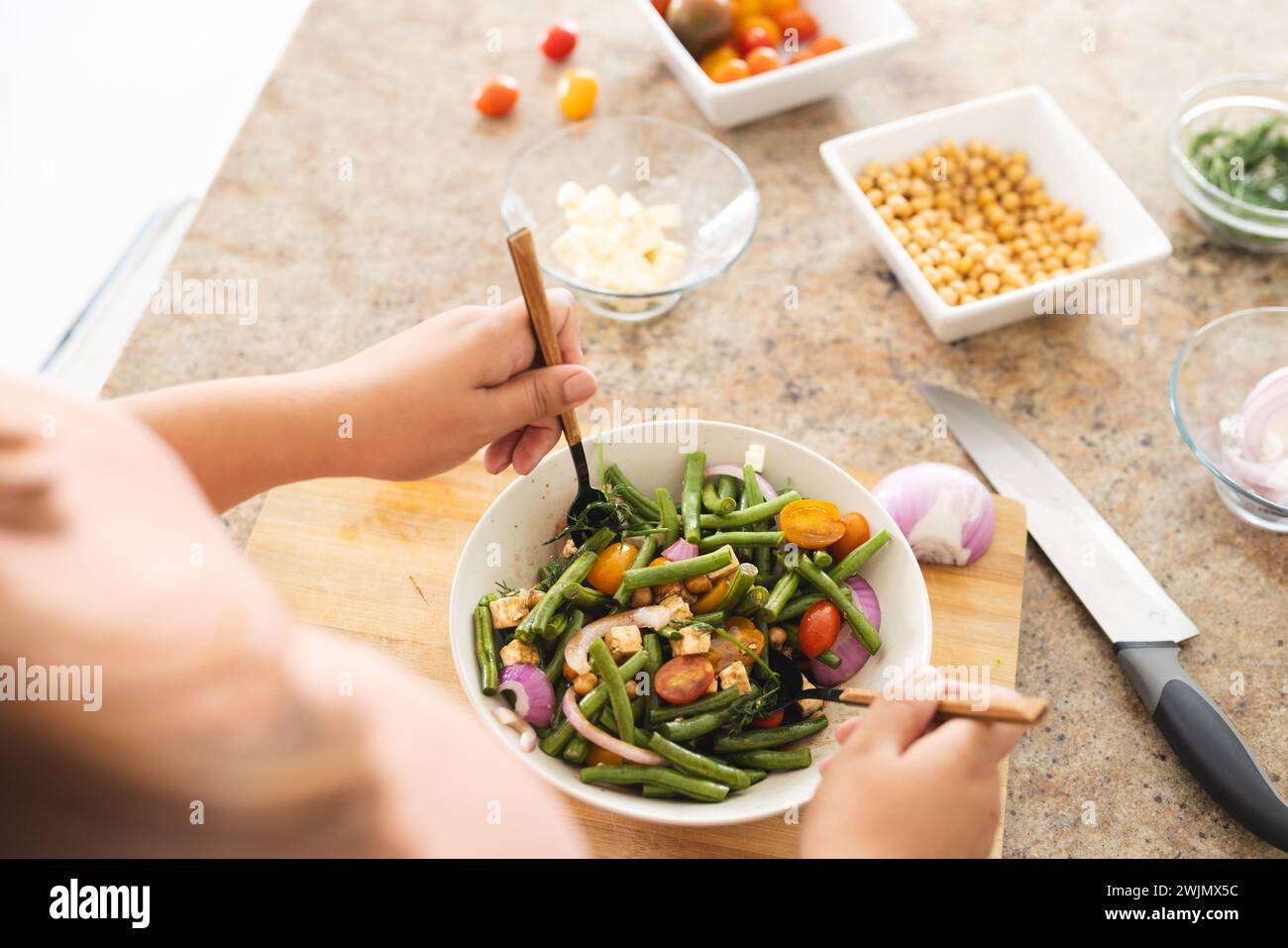 Young plus size biracial woman enjoys a healthy meal at home unaltered ...