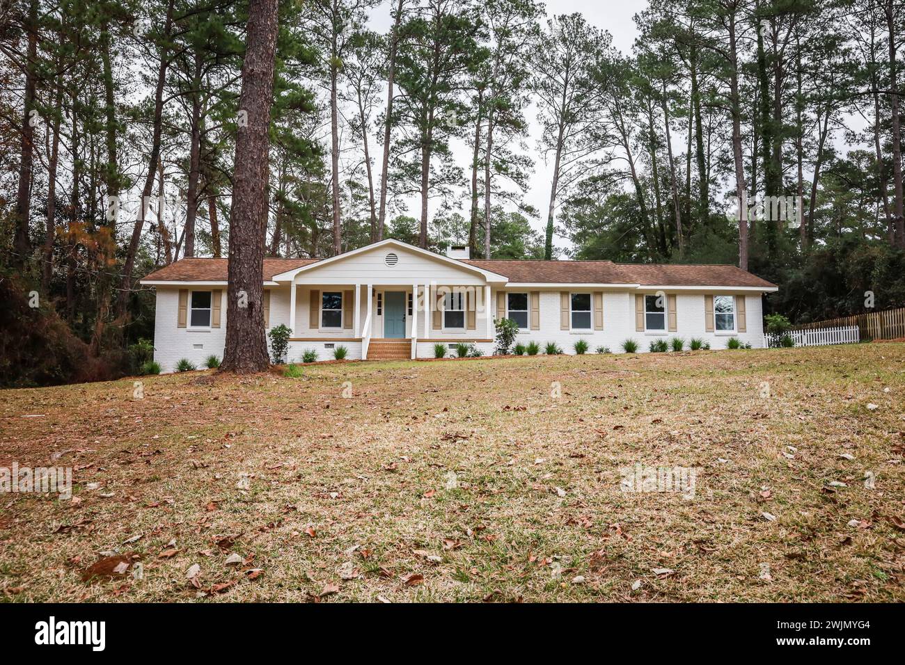 The front exterior entrance of a newly painted white siding brick ranch ...
