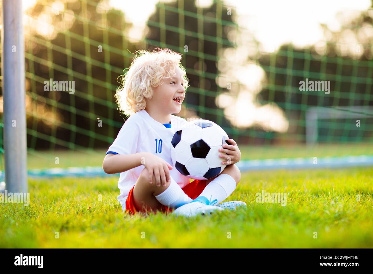 Kids play football on outdoor field. England team fans. Children score ...