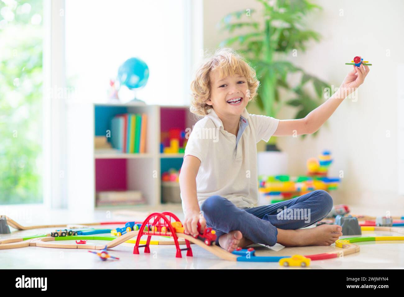 Kids play with toy train railway. Child playing with colorful rainbow ...