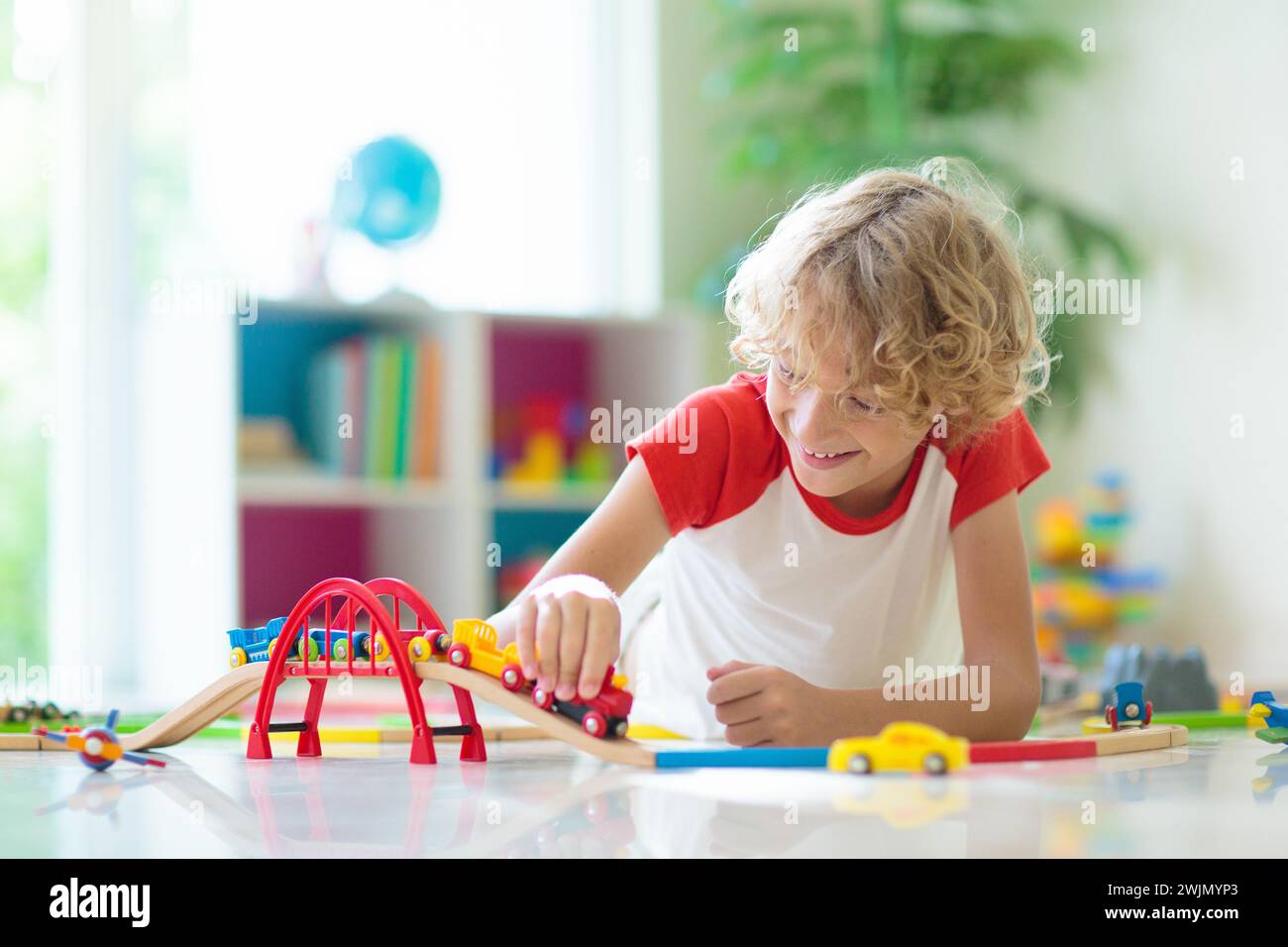 Kids play with toy train railway. Child playing with colorful rainbow ...