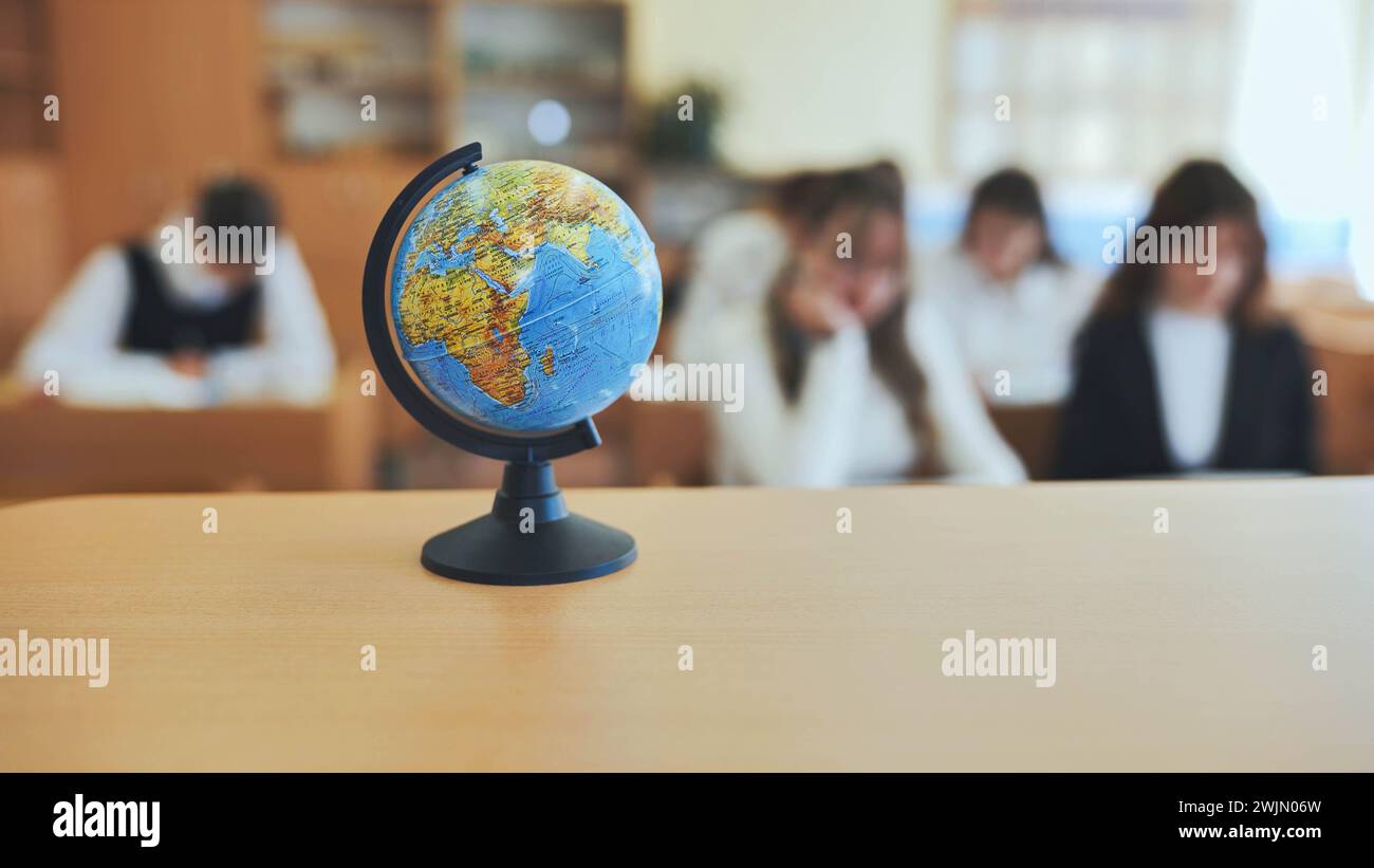 A globe of the world with textbooks in the background of a lesson in a ...