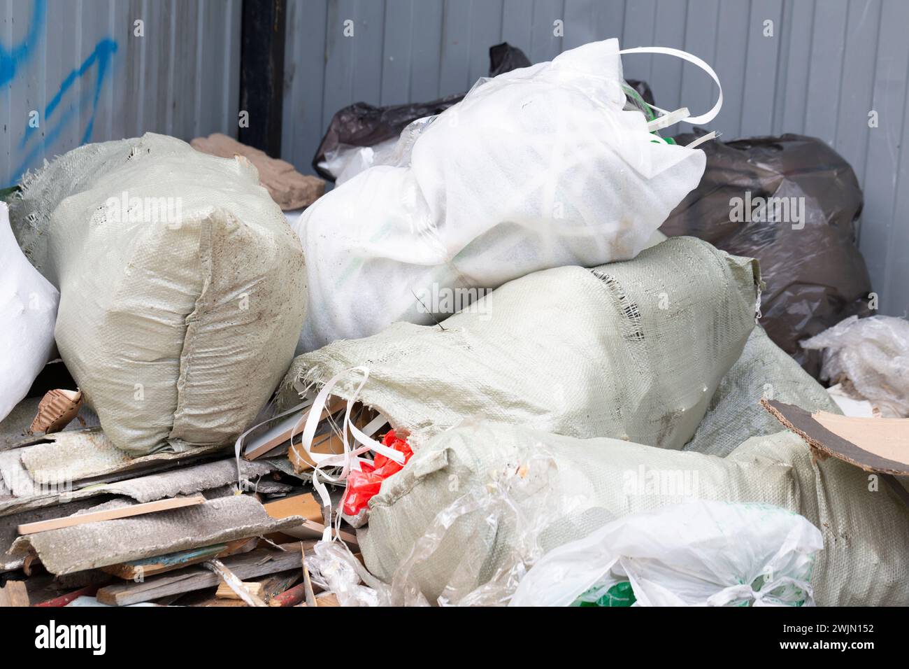 A bunch of construction debris in white bags near a new building ...