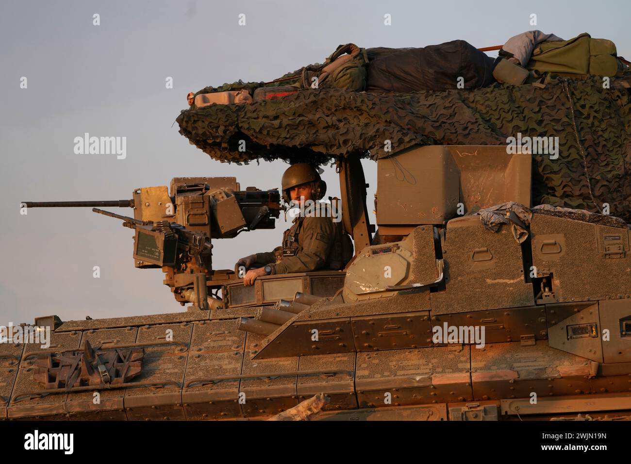 An Israeli soldier smiles from the turret of his armored vehicle in ...