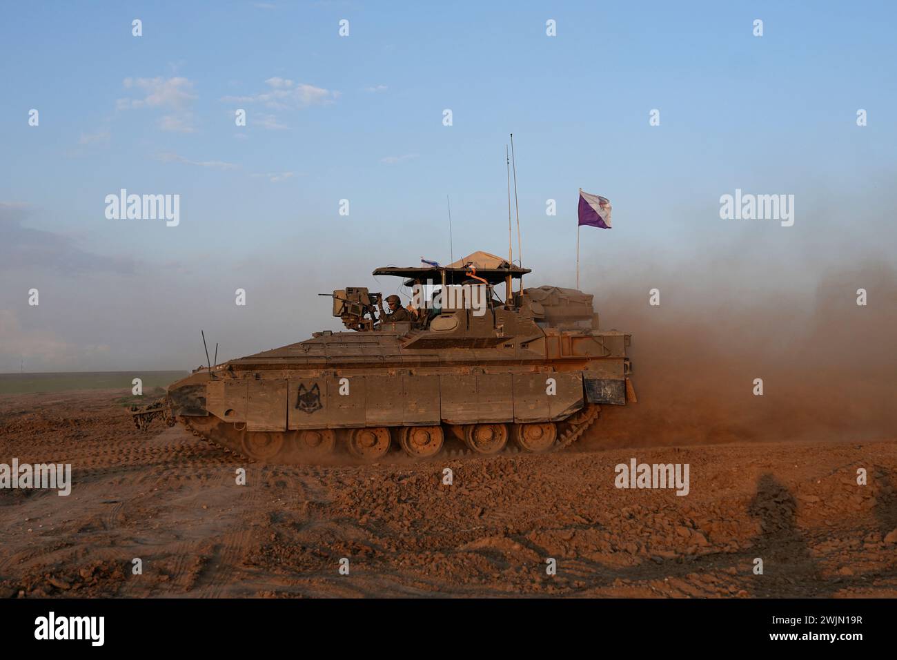 An Israeli soldier stands in the turret of his armored vehicle in ...