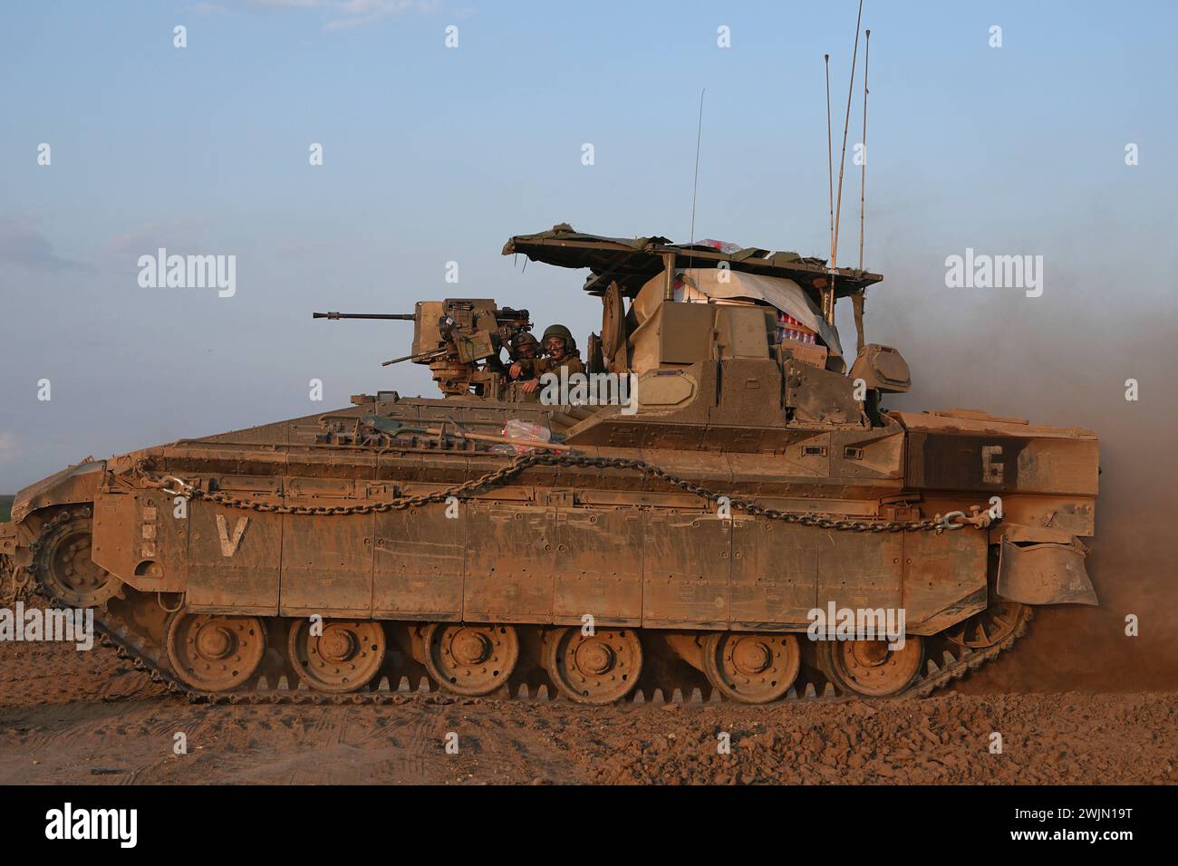 An Israeli soldier smiles from the turret of his armored vehicle in ...