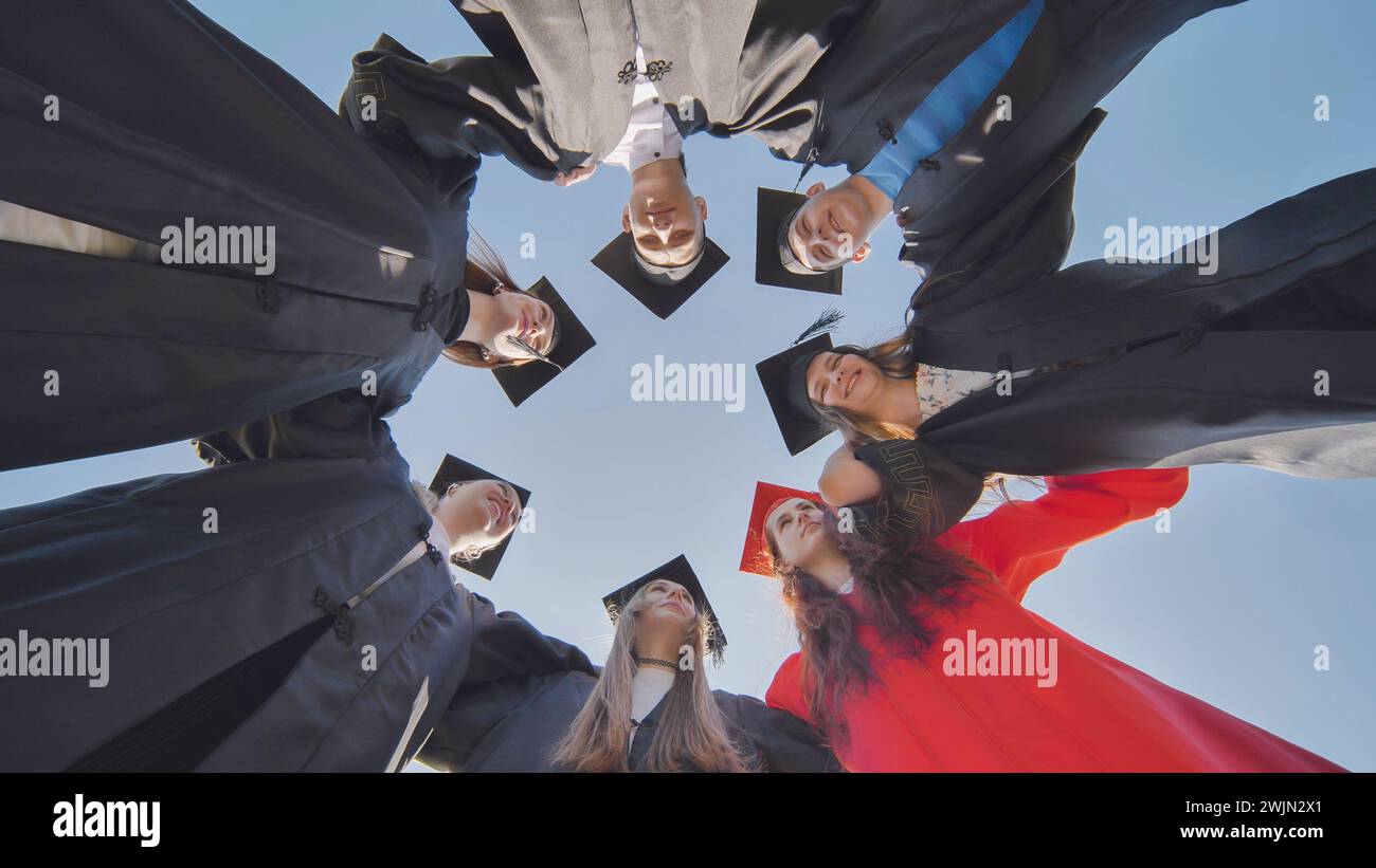 College graduates in a circle stand hugging each other Stock Photo - Alamy