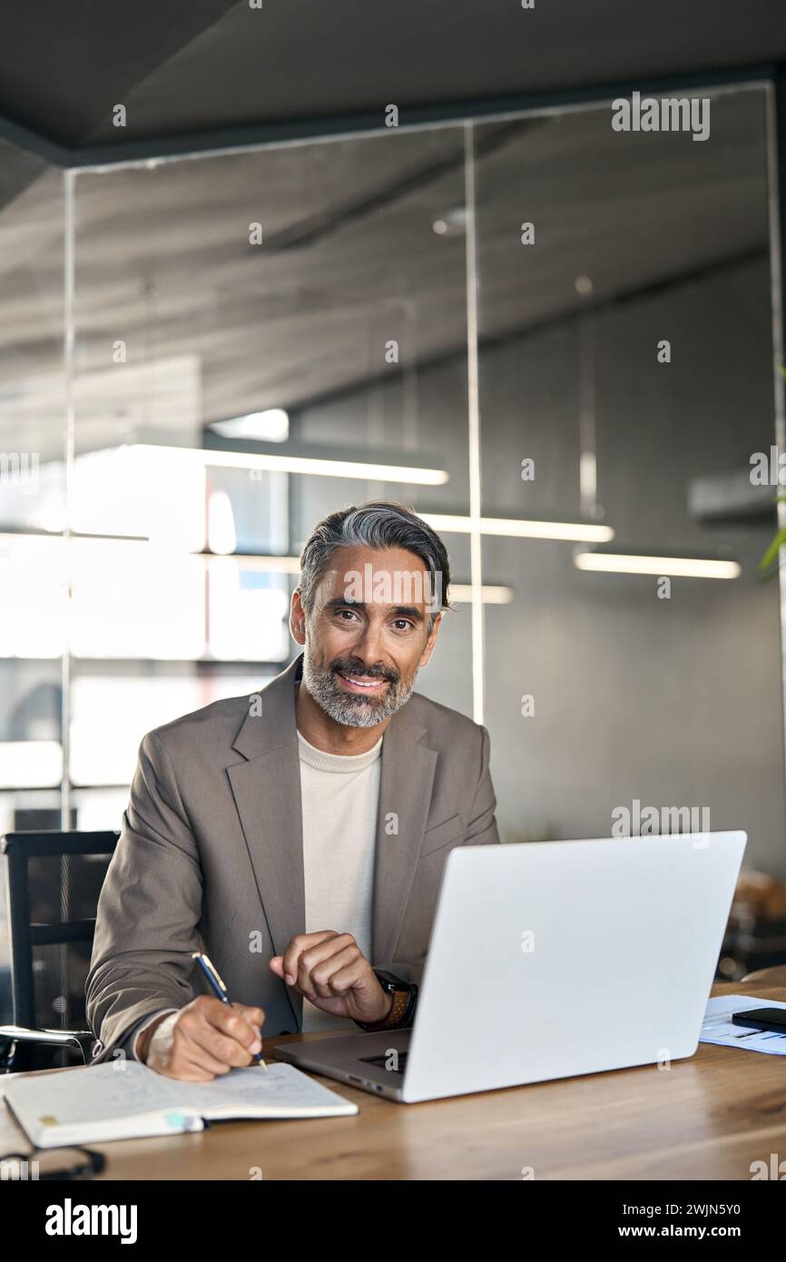 Happy middle aged business man working on laptop in office, portrait Stock Photo - Alamy