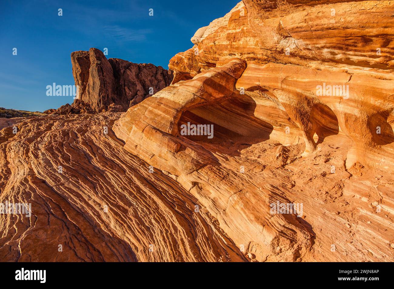 A small piano-leg arch in a colorful eroded Aztec sandstone formation ...