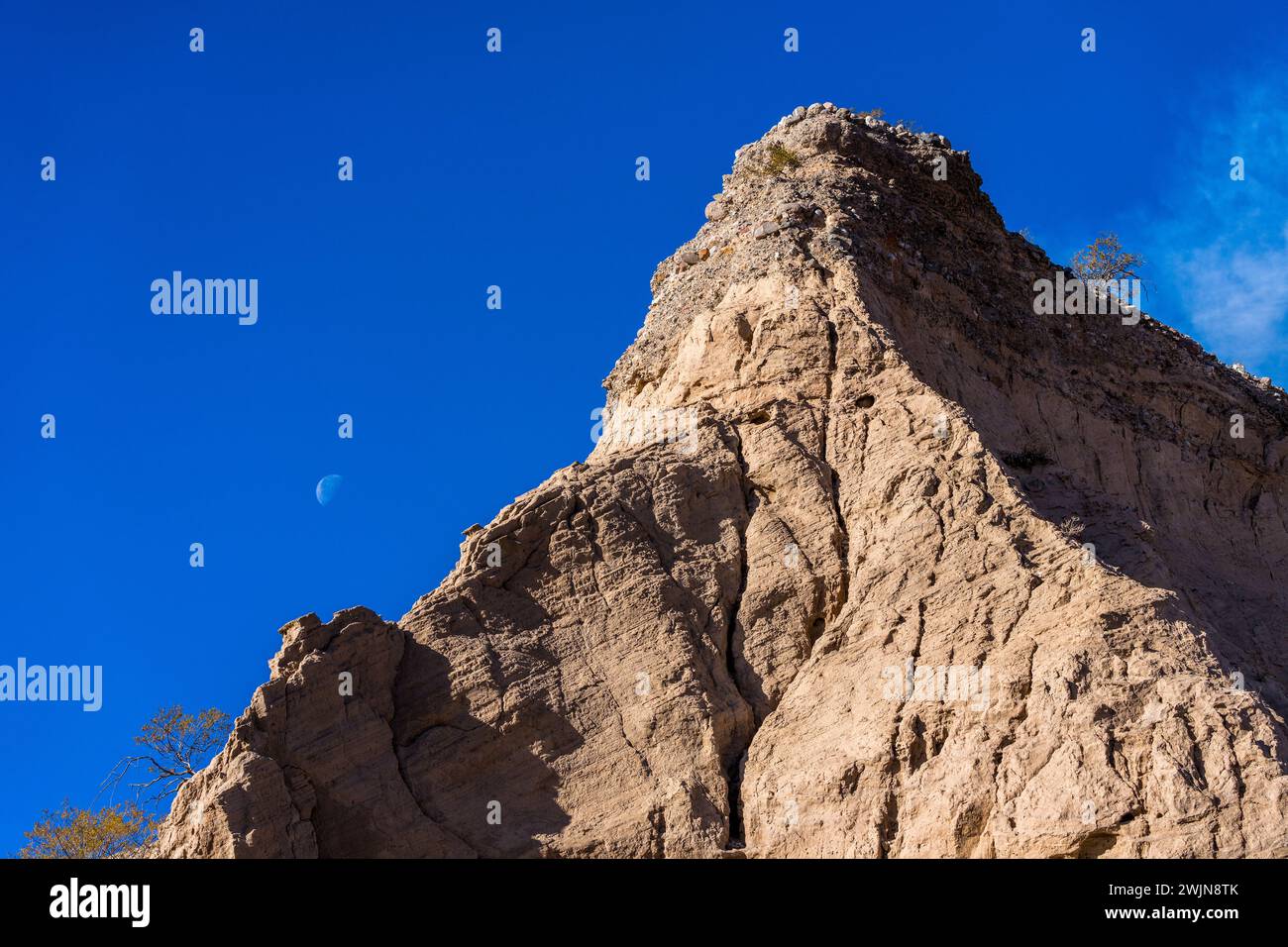 An eroded hill with the moon in the Bosque dle Apache Wildlife Reserve ...