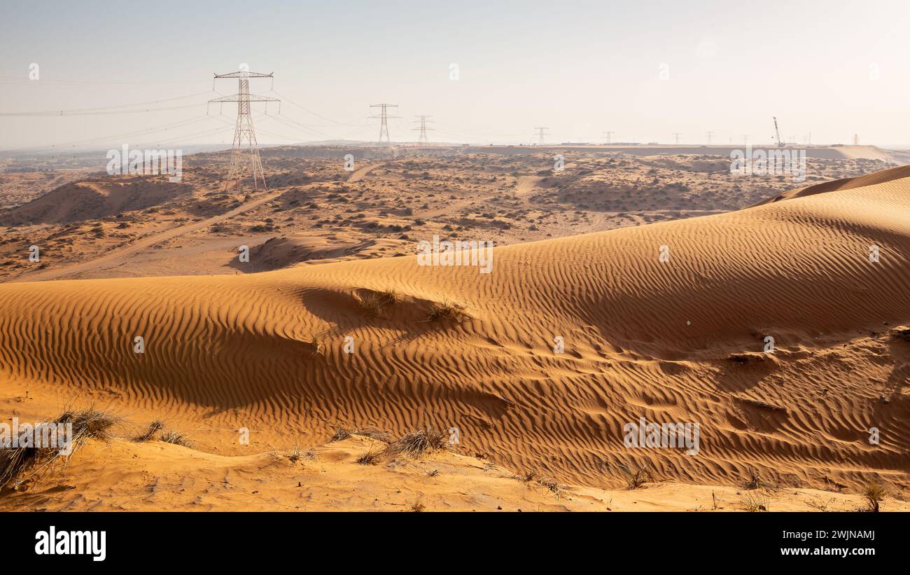 Golden desert dunes landscape with transmission towers on the horizon ...