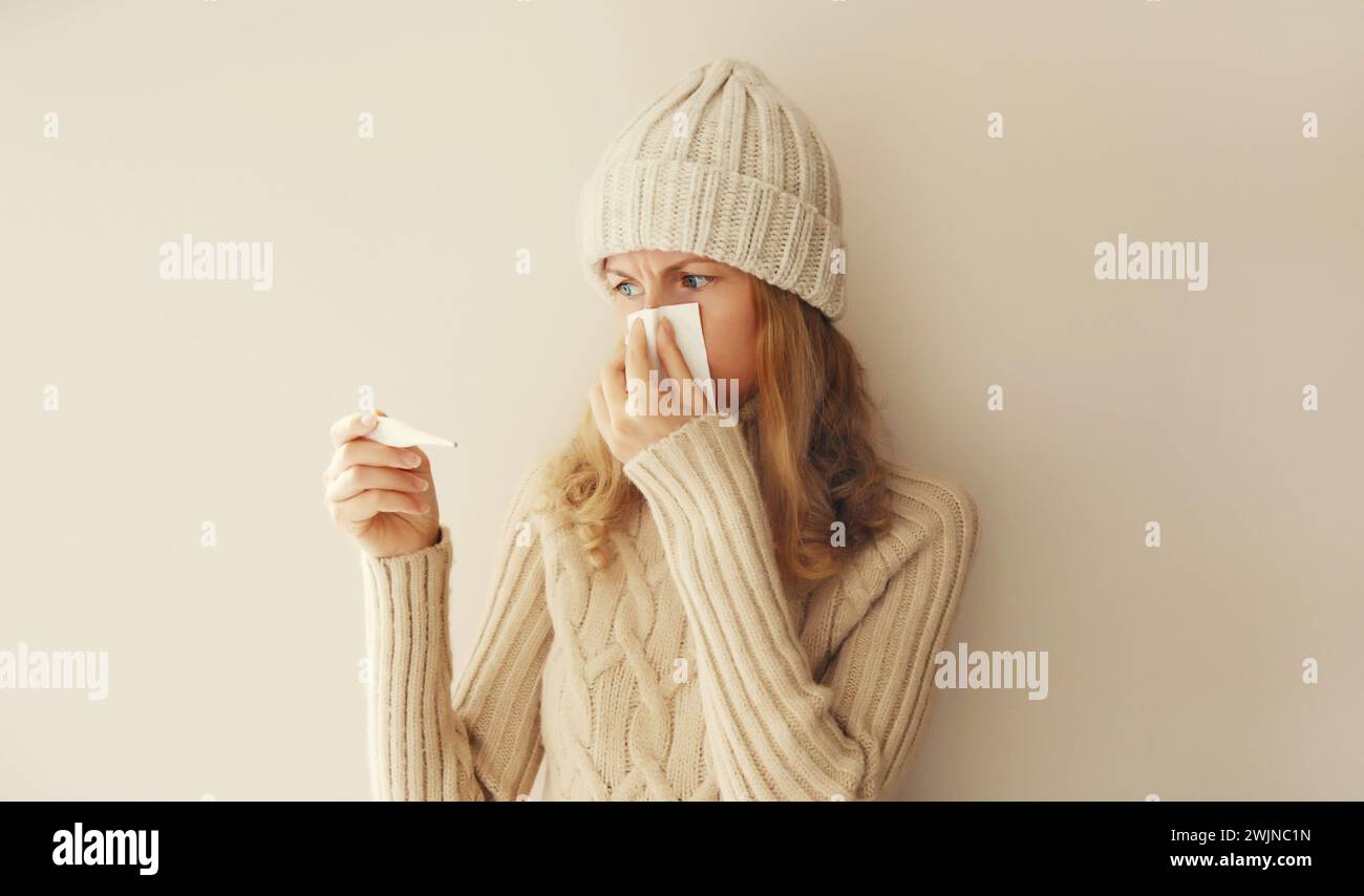 Sick woman sneezing blow nose using tissue and measuring checking body ...