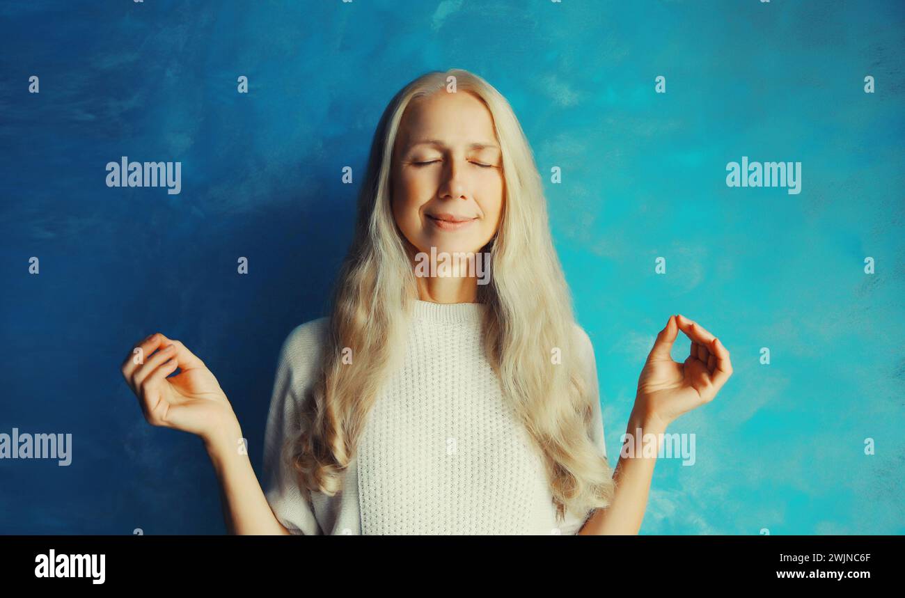Relaxed caucasian middle aged woman meditates in yoga lotus position ...