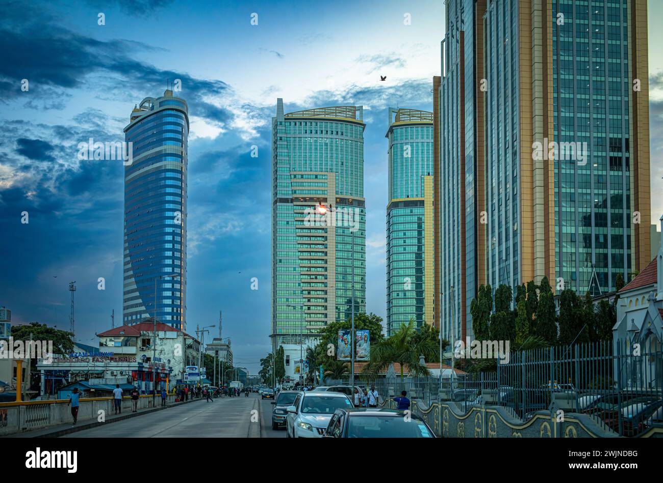 Traffic drives down Sokoine Drive at dusk away from modern high rise ...