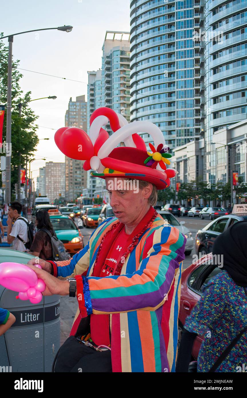 Street artists inflating animal balloons in downtown district, Toronto ...