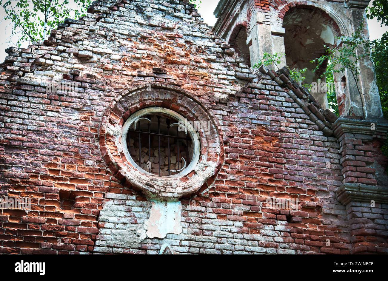 Fragment of a brick wall with a window with a lattice of a medieval ...