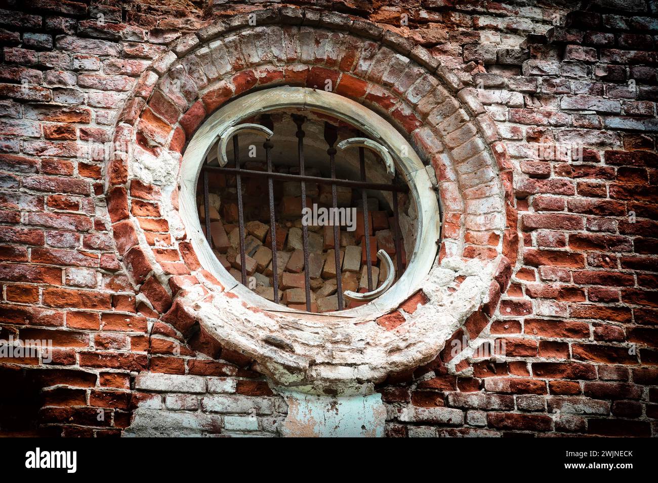 Fragment of a brick wall with a window with a lattice of a medieval ...