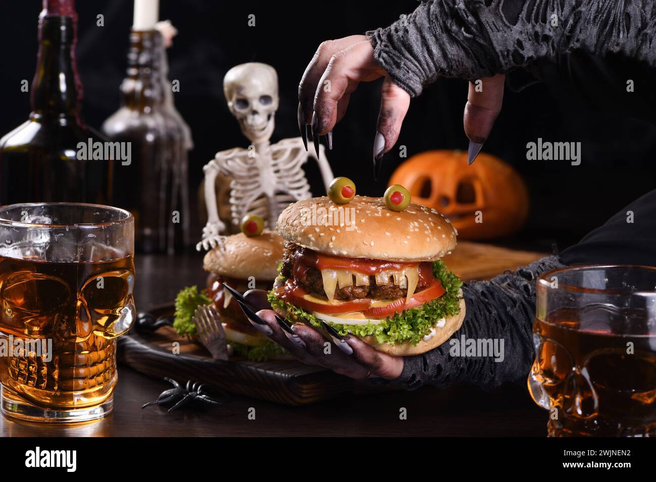 The witches hands hold a Monster Burger in her palms on a sitting ...