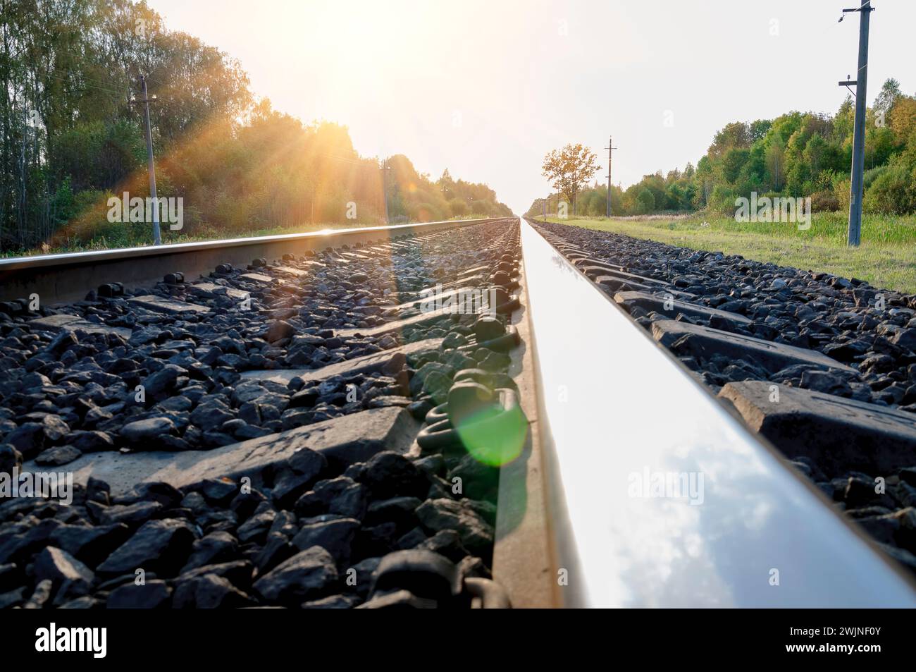 Railroad tracks stretching into the distance. The horizon is flooded with sunlight Stock Photo ...
