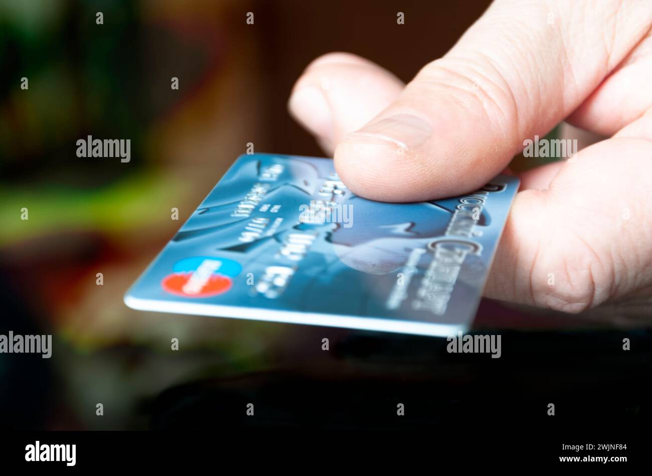 Male hand holding a payment card. Blue card Stock Photo - Alamy