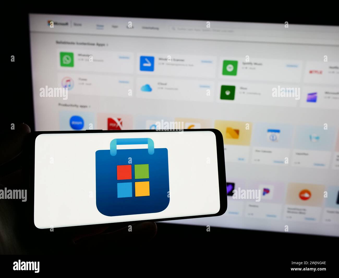 Person holding smartphone with logo of digital distribution platform ...