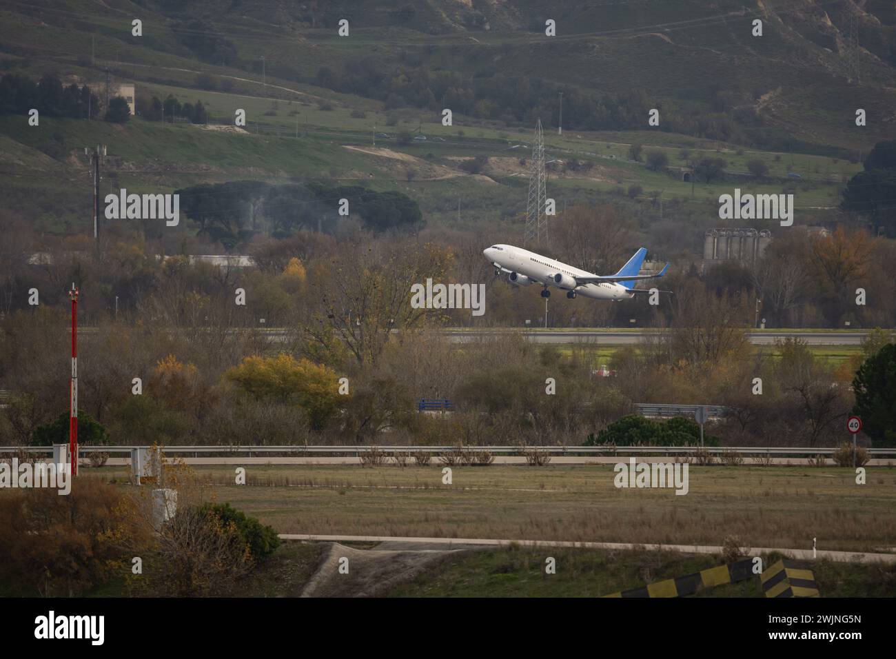 A passenger plane with two turbines under the wings taking off from an ...