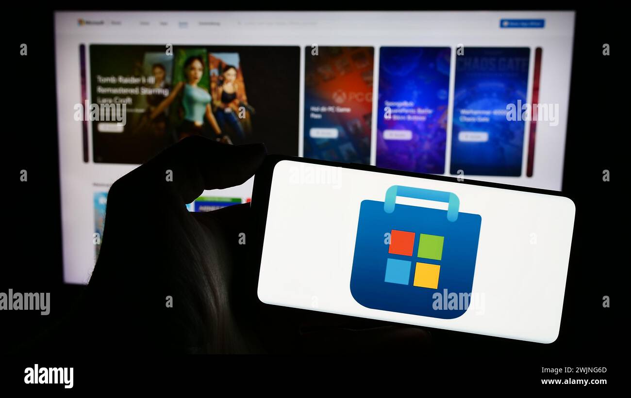 Person holding cellphone with logo of digital distribution platform ...