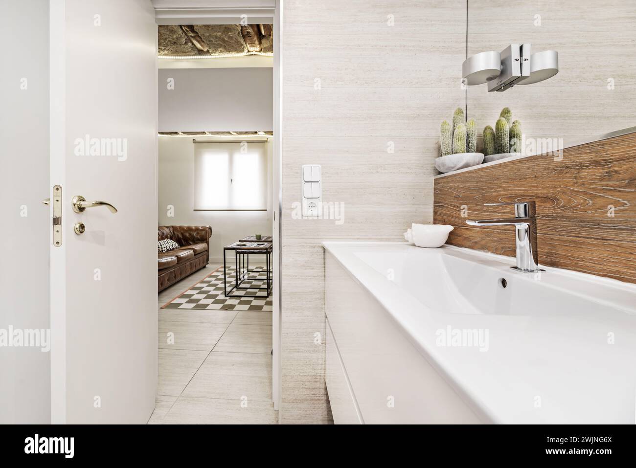 Image of a bathroom with white furniture, tiled wall with wood-look ...