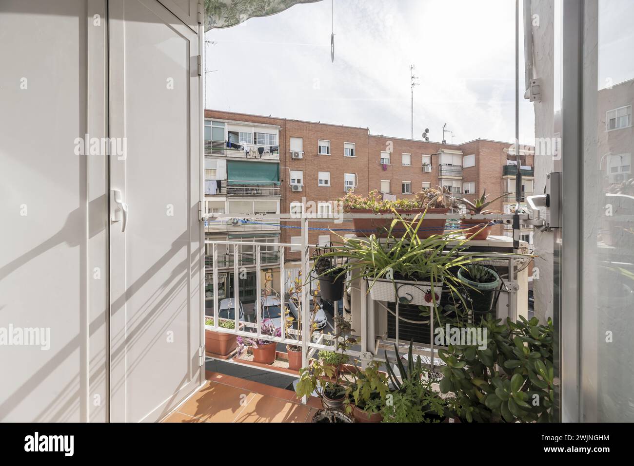 A small terrace with a white aluminum cabinet, metal railing and quite ...