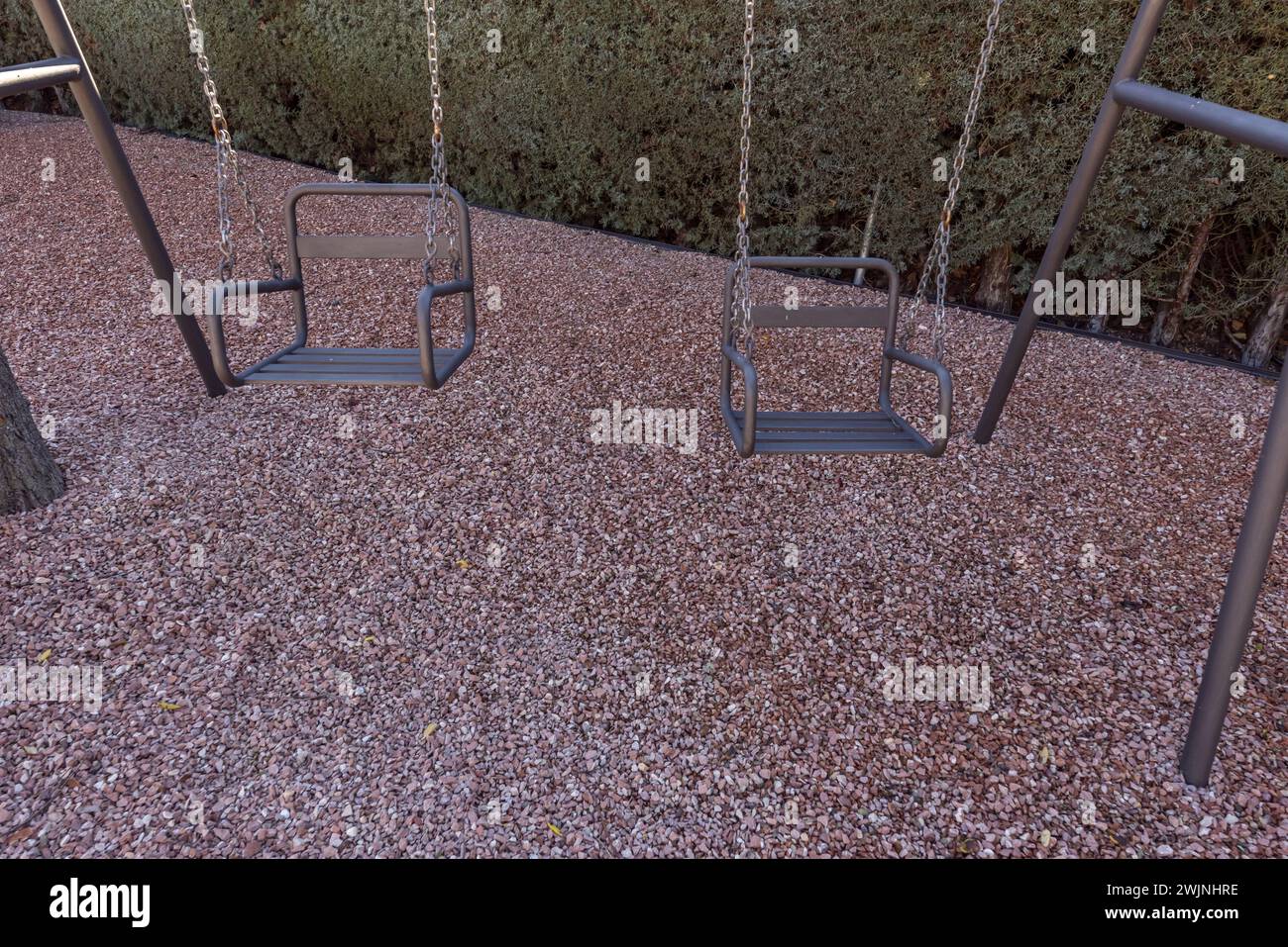 A pair of swings with chains in a recreational area within an ...
