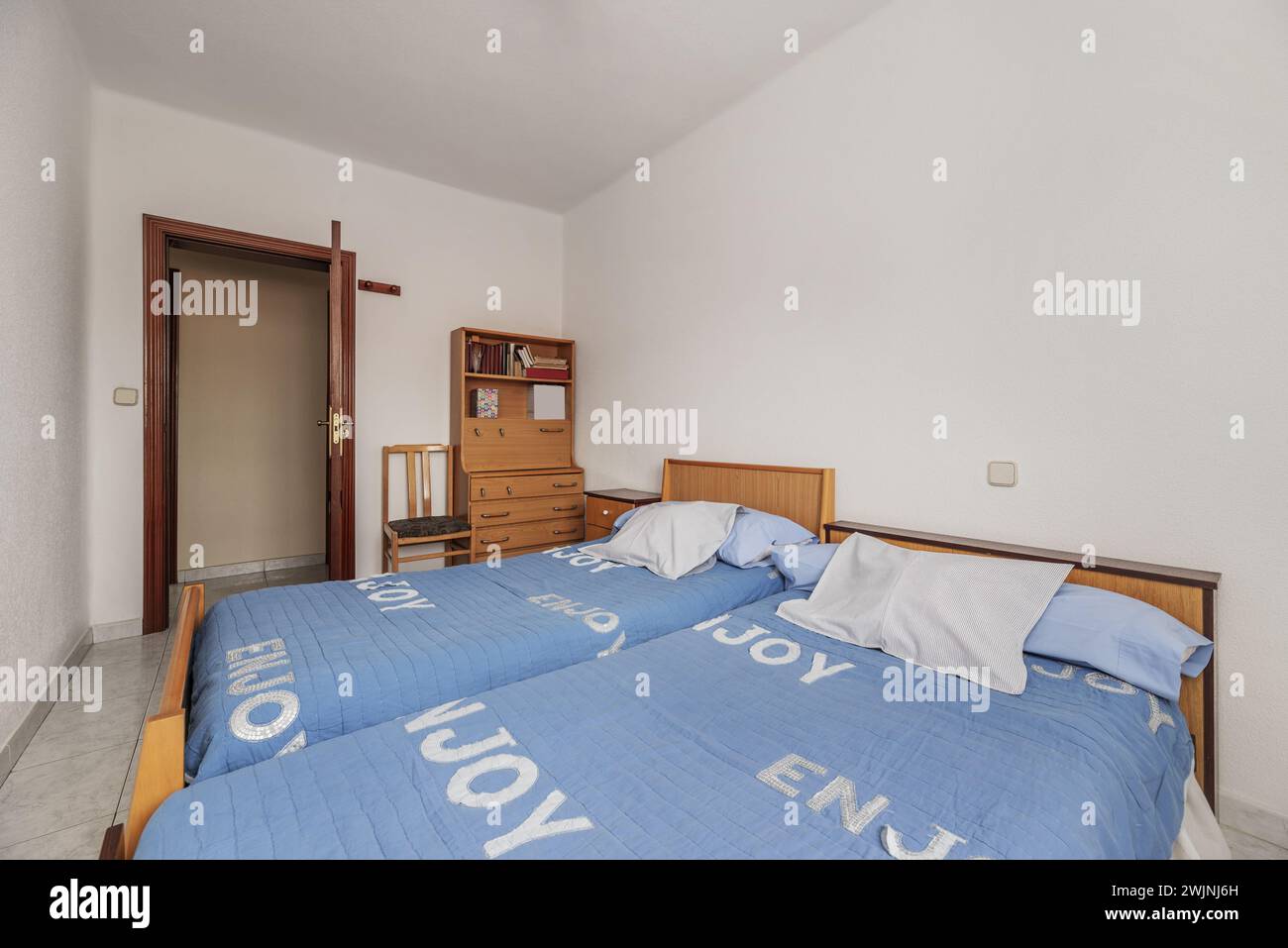 Bedroom with twin single beds with blue bedspreads and old wooden ...