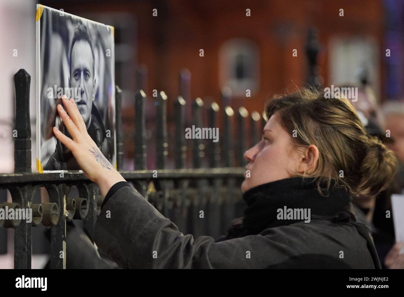 A women touches a picture of Alexei Navalny at a protest opposite the ...