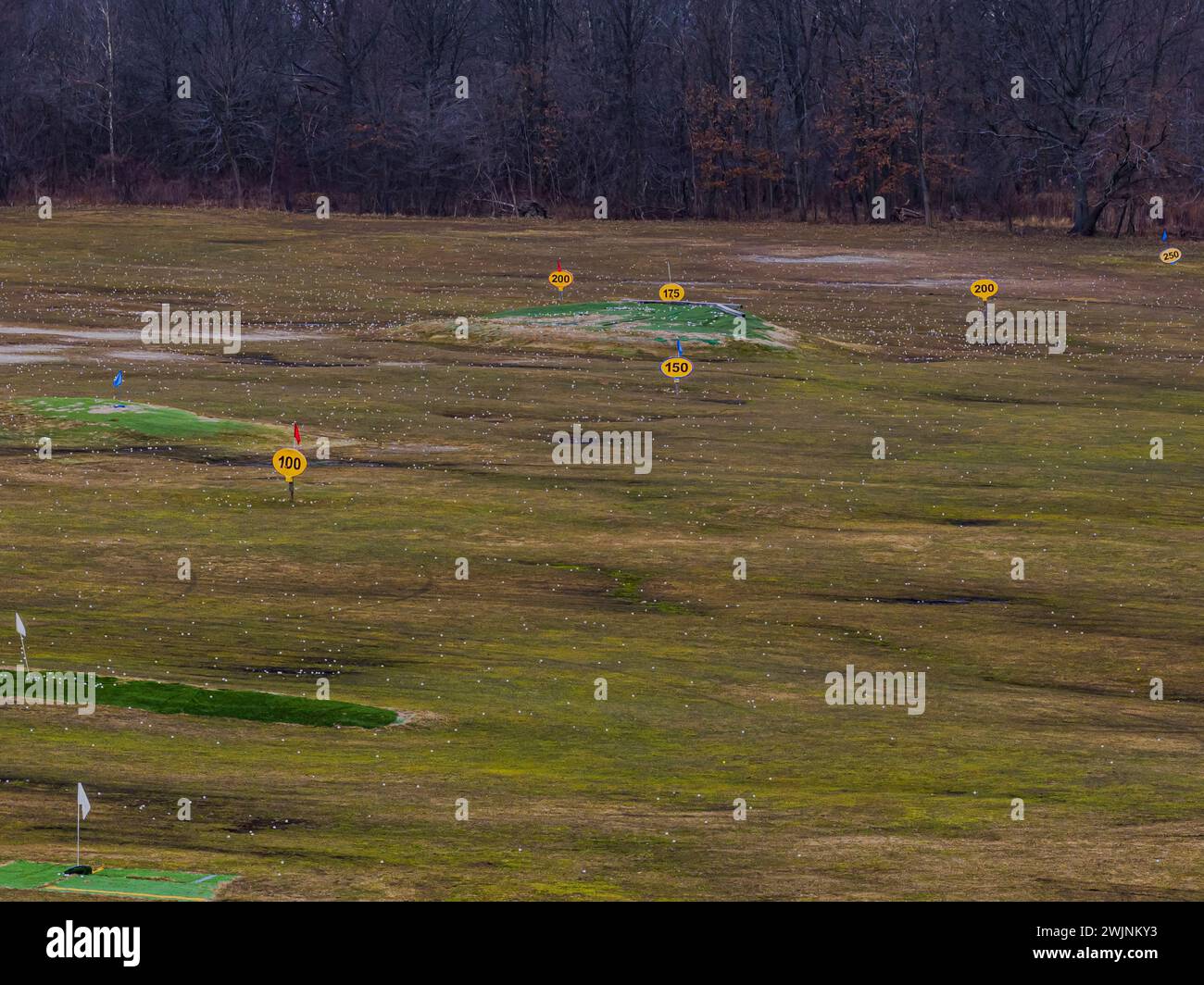 An aerial view of an empty golf driving range with dry grass on a ...