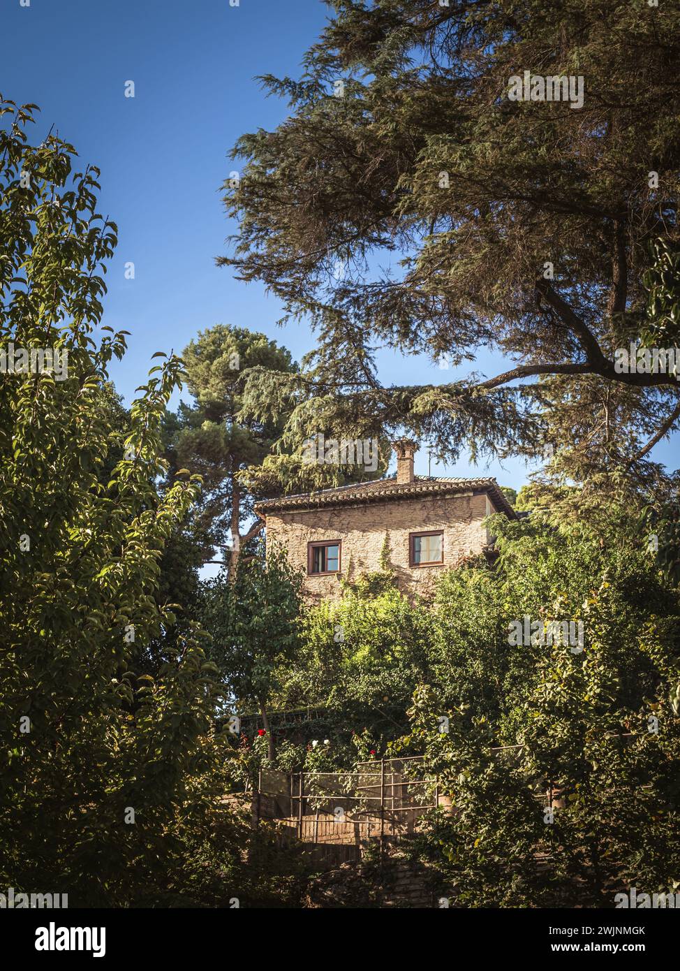 A bastion tower between trees inside the Alhambra palace complex in ...