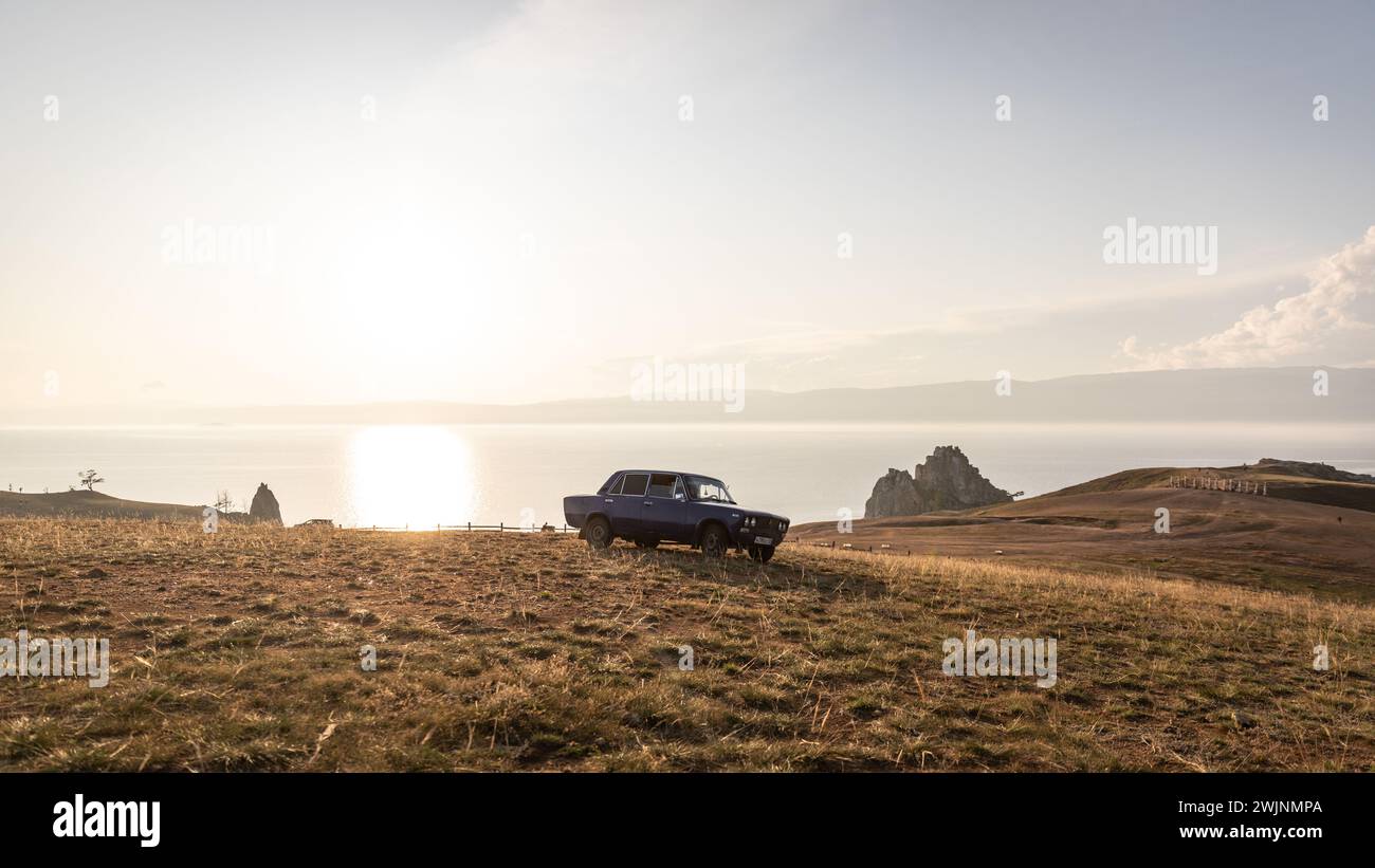 A Lada stands above the sacred Shaman Rock on Olkhon Island on Lake ...