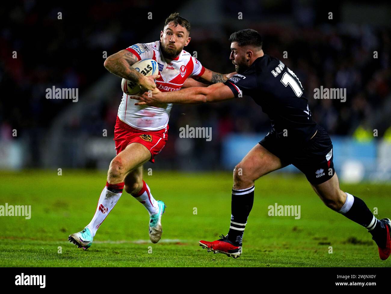 St Helens' Daryl Clark (left) is tackled by London Broncos' Will Lovell ...