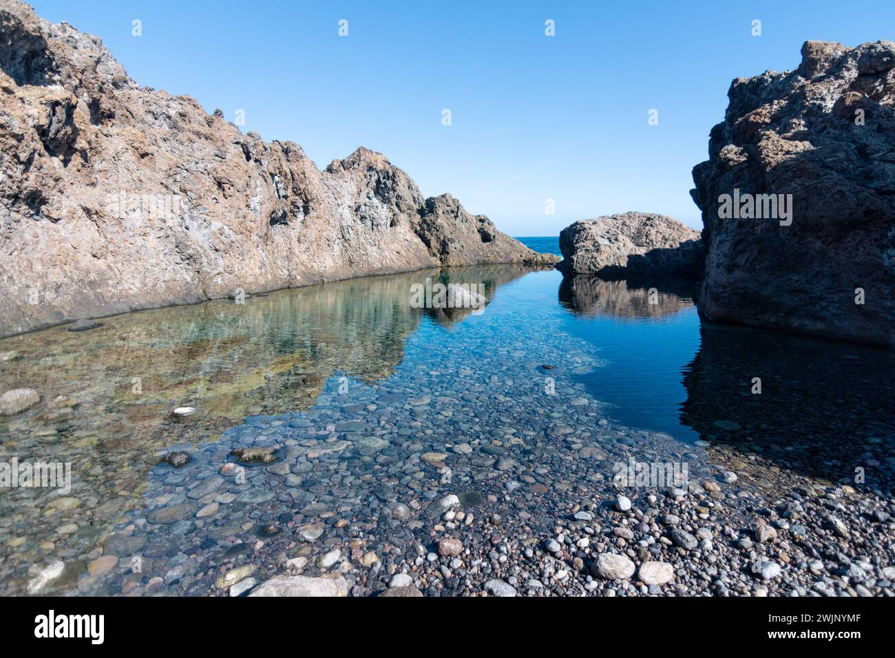 Natural pool of volcanic rocks in Tenerife submerged in the water. High ...