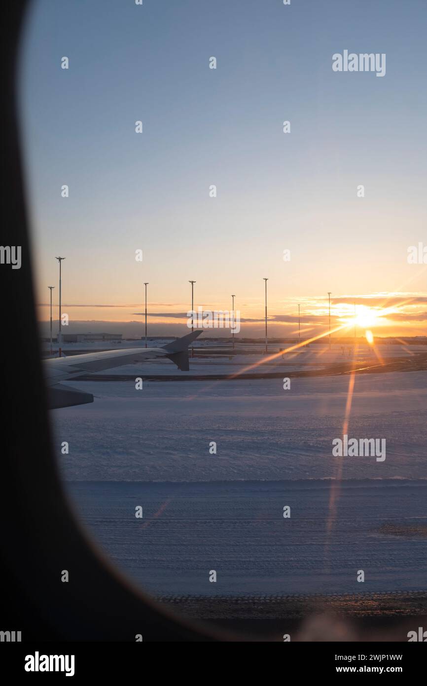 Sunset dusk shining on a snowy landing airport track seen from an ...