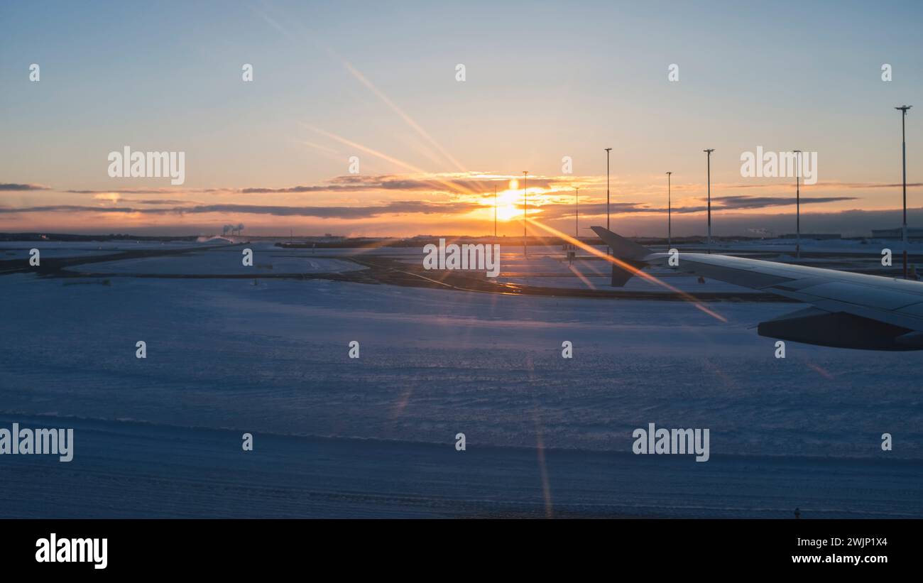 Sunset dusk shining on a snowy landing airport track seen from an ...
