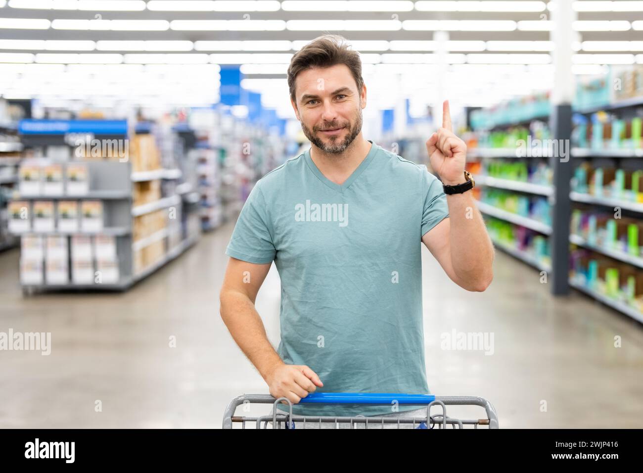 Handsome man with shopping basket with shopping trolley at grocery. Man ...