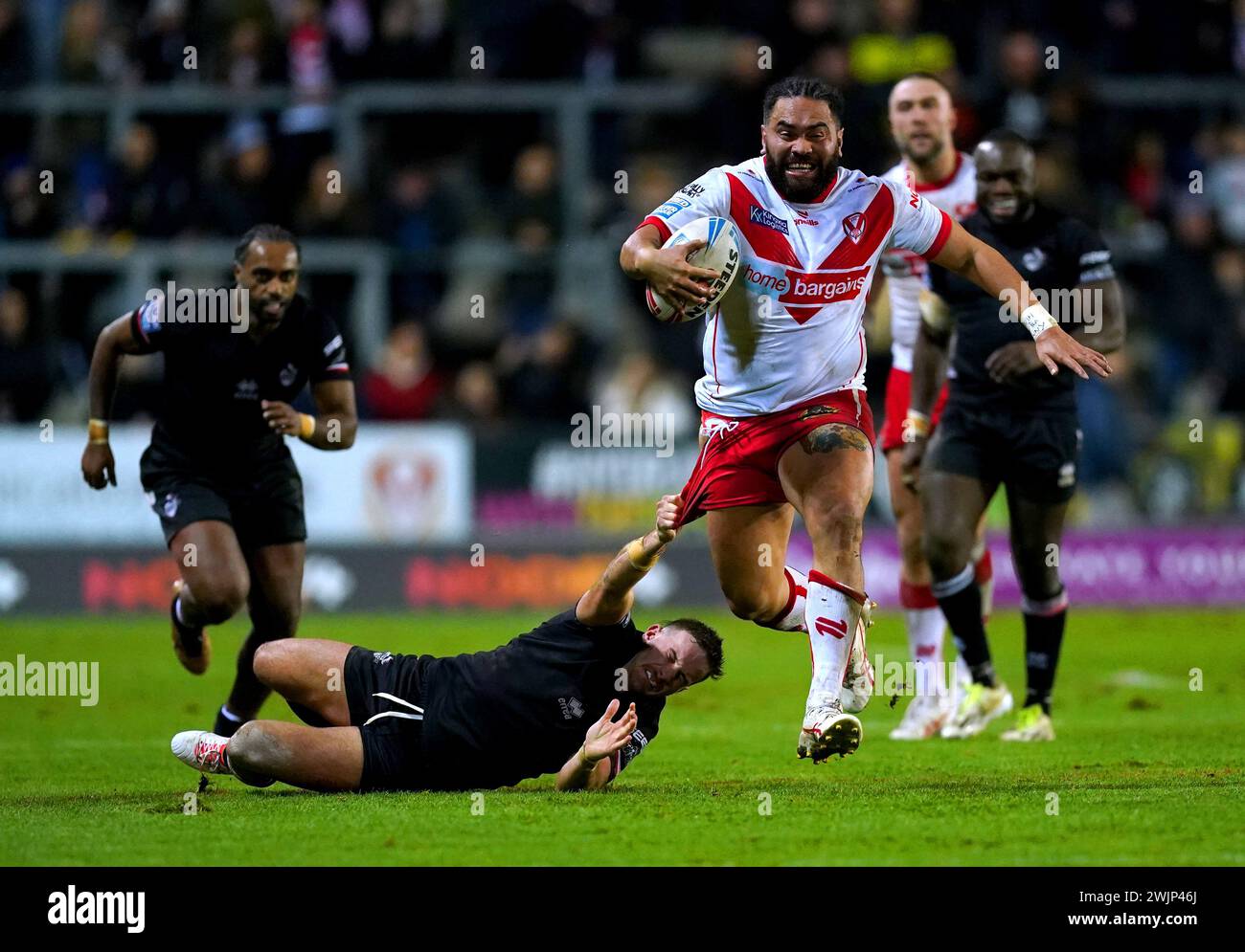 St Helens' Konrad Hurrell (right) avoids being tackled by London ...