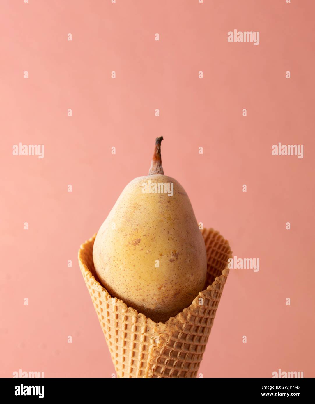 Frozen pear in ice cream cone on pink pastel background. Fruit creative ...
