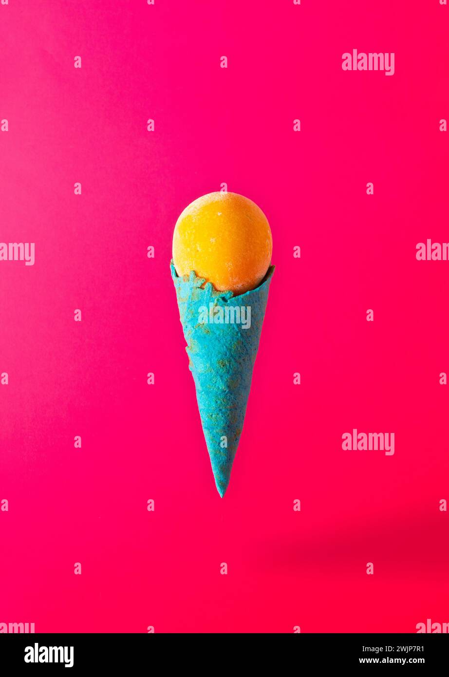 Creative tropical layout with frozen lemon, blue cone and pink vivid ...