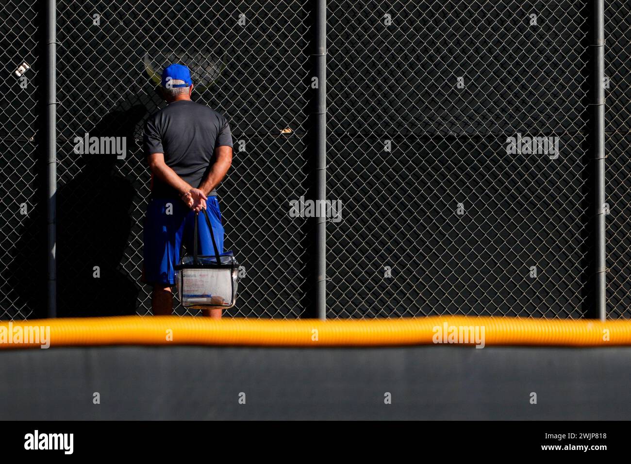 A fan peers through a hole in an outfield tarp at a Kansas City Royals ...