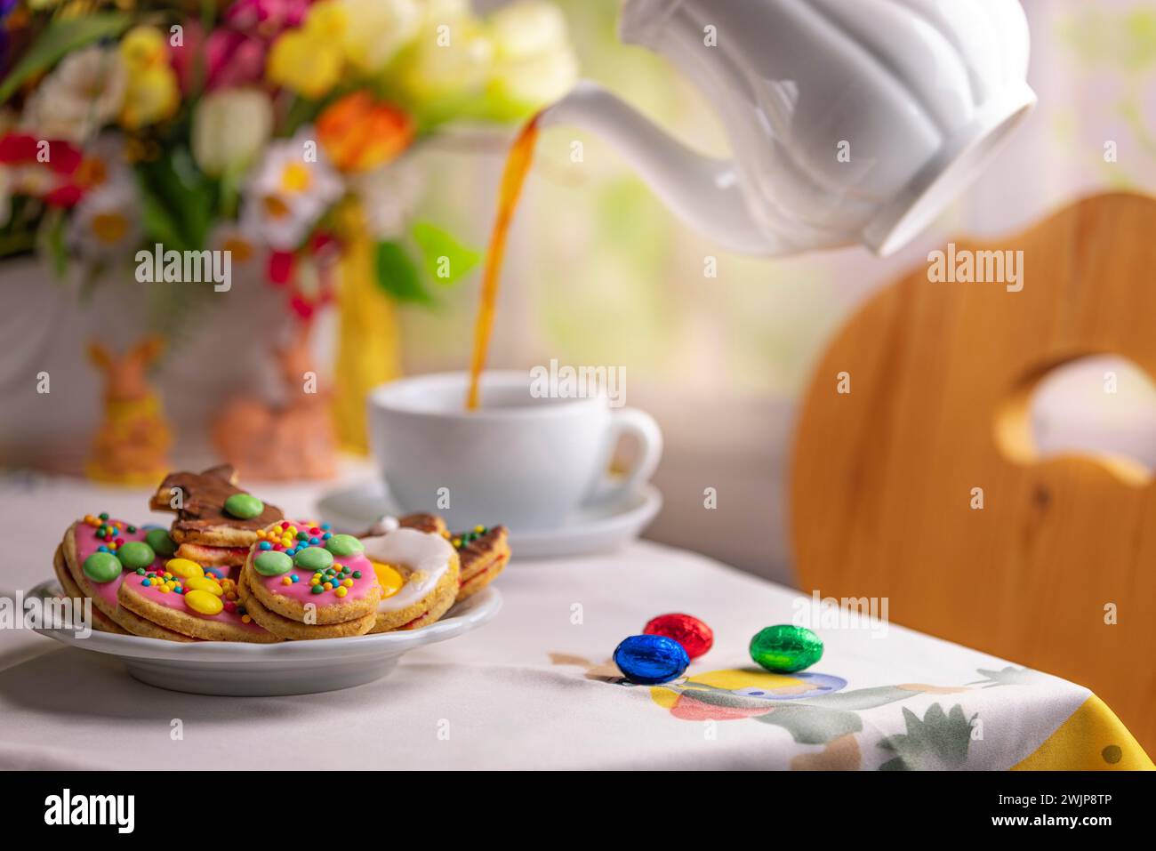 Breakfast scene with Easter biscuits and coffee being poured into a cup ...