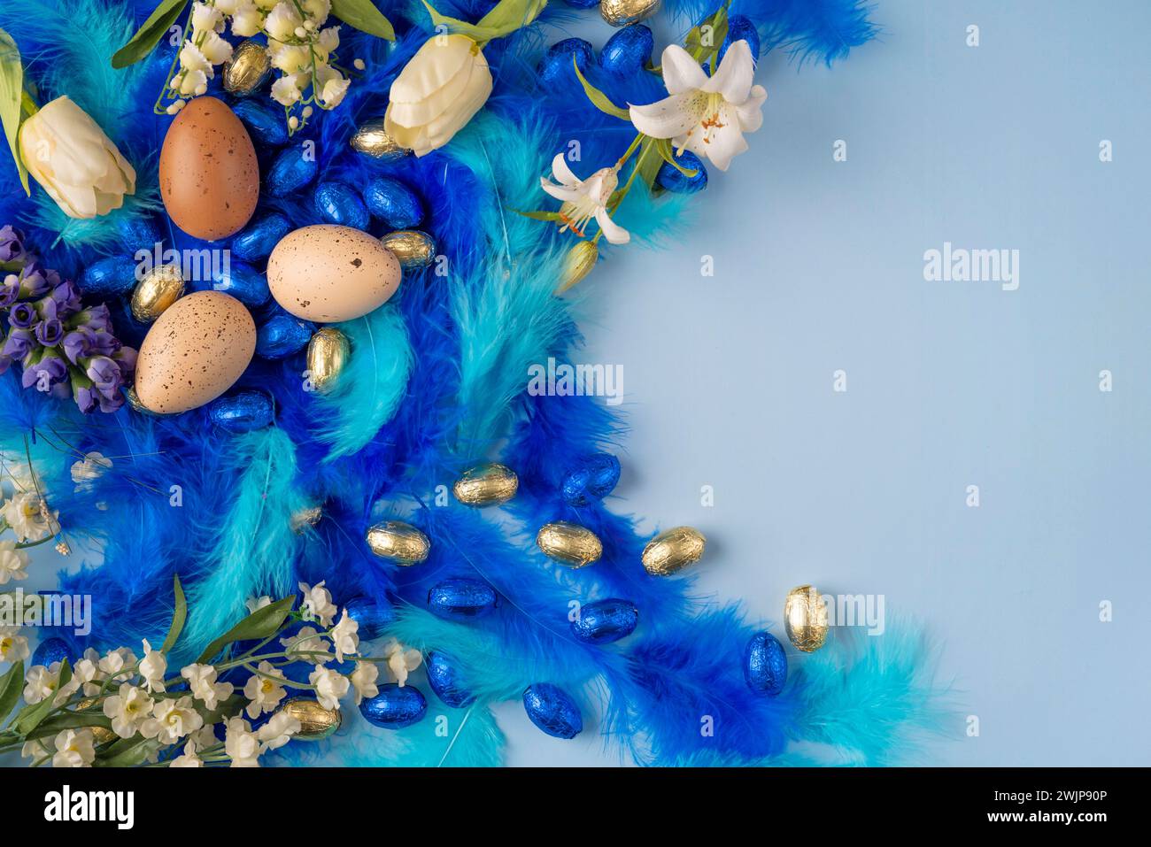 A spring-like Easter egg decoration with blue feathers and white ...