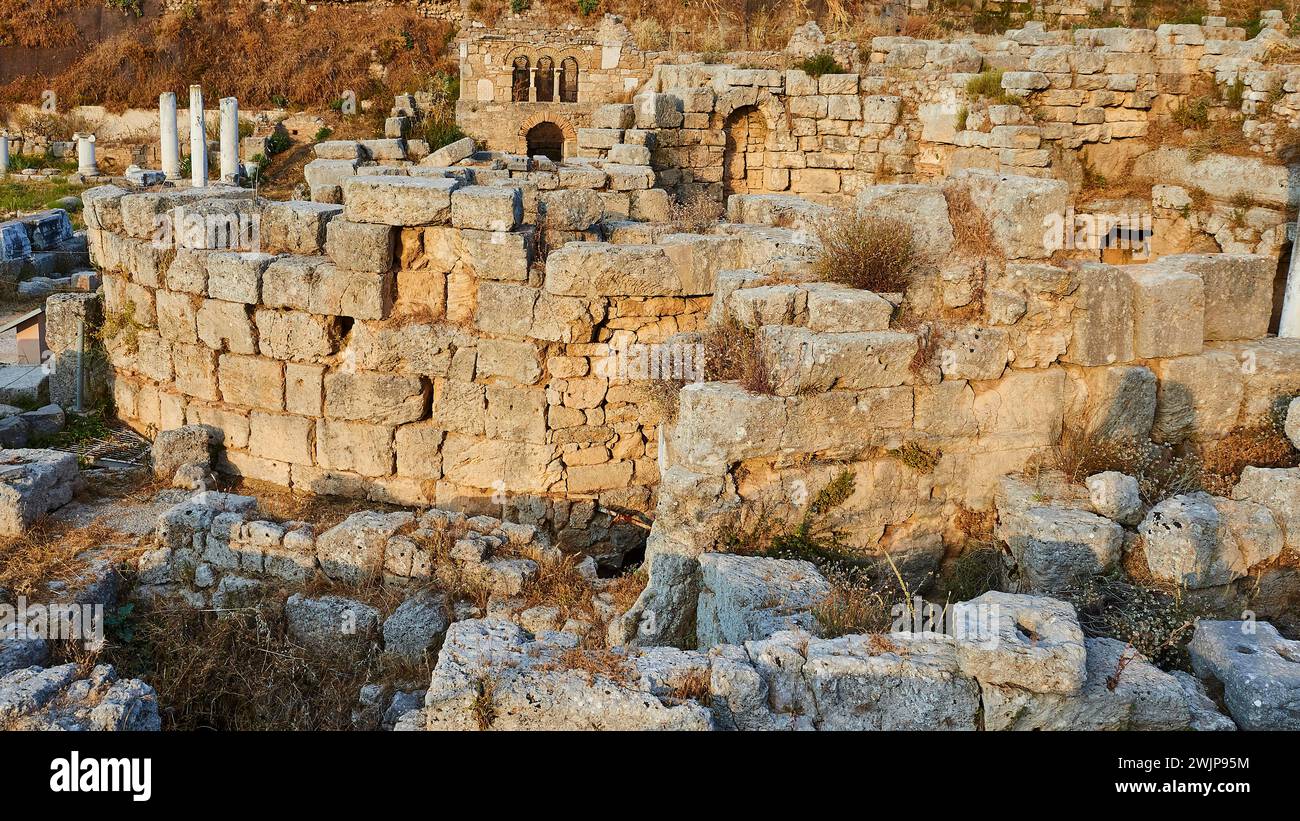 Sunlit ancient ruins with robust stone walls and some shrubs ...